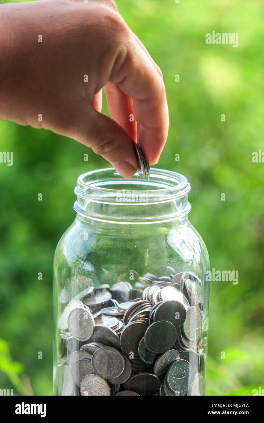 hand putting money coins Stock Photo - Alamy