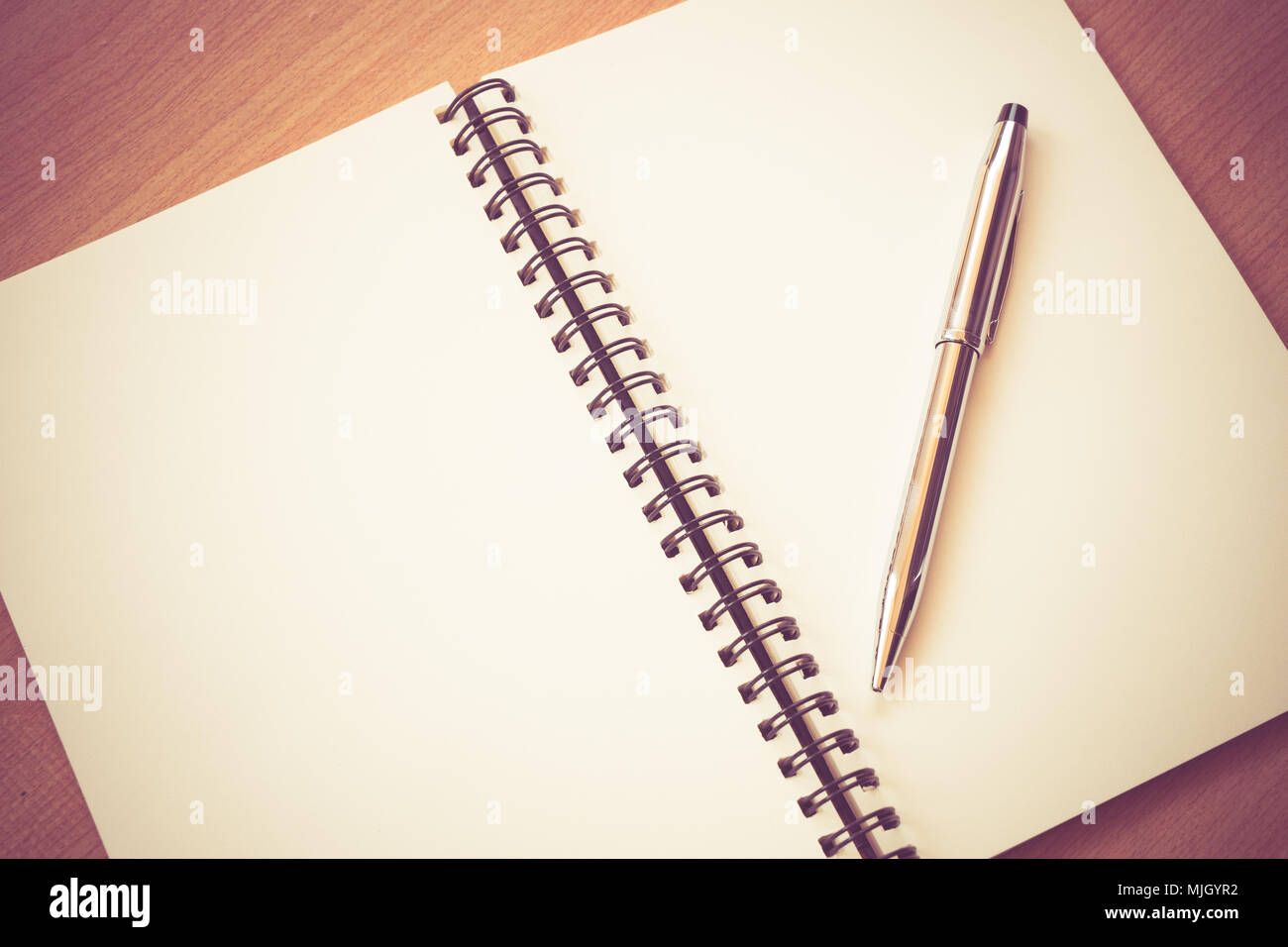 paper notebook and pen on a table with filter effect retro vintage ...