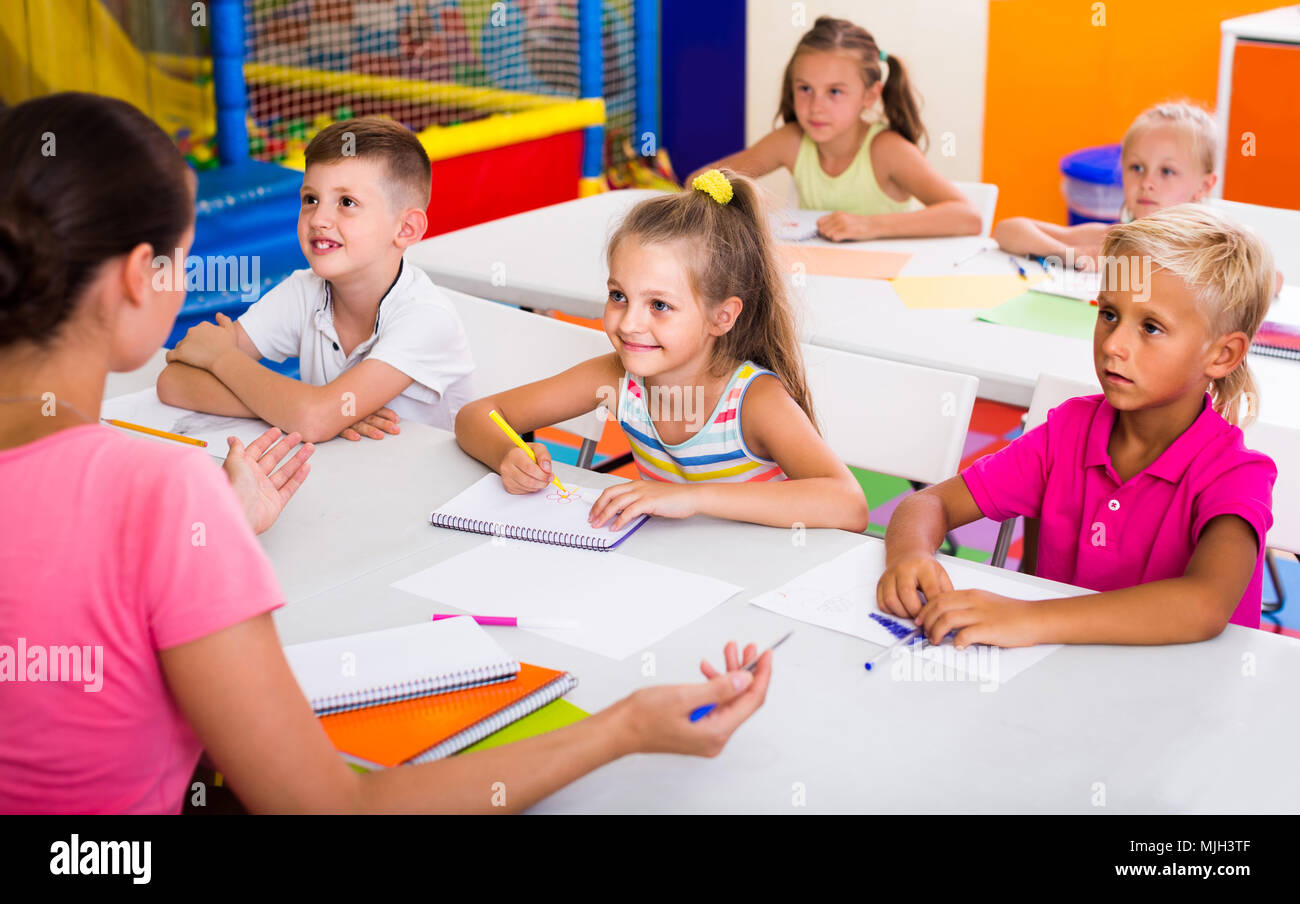 american children sitting together and studying in class at school ...