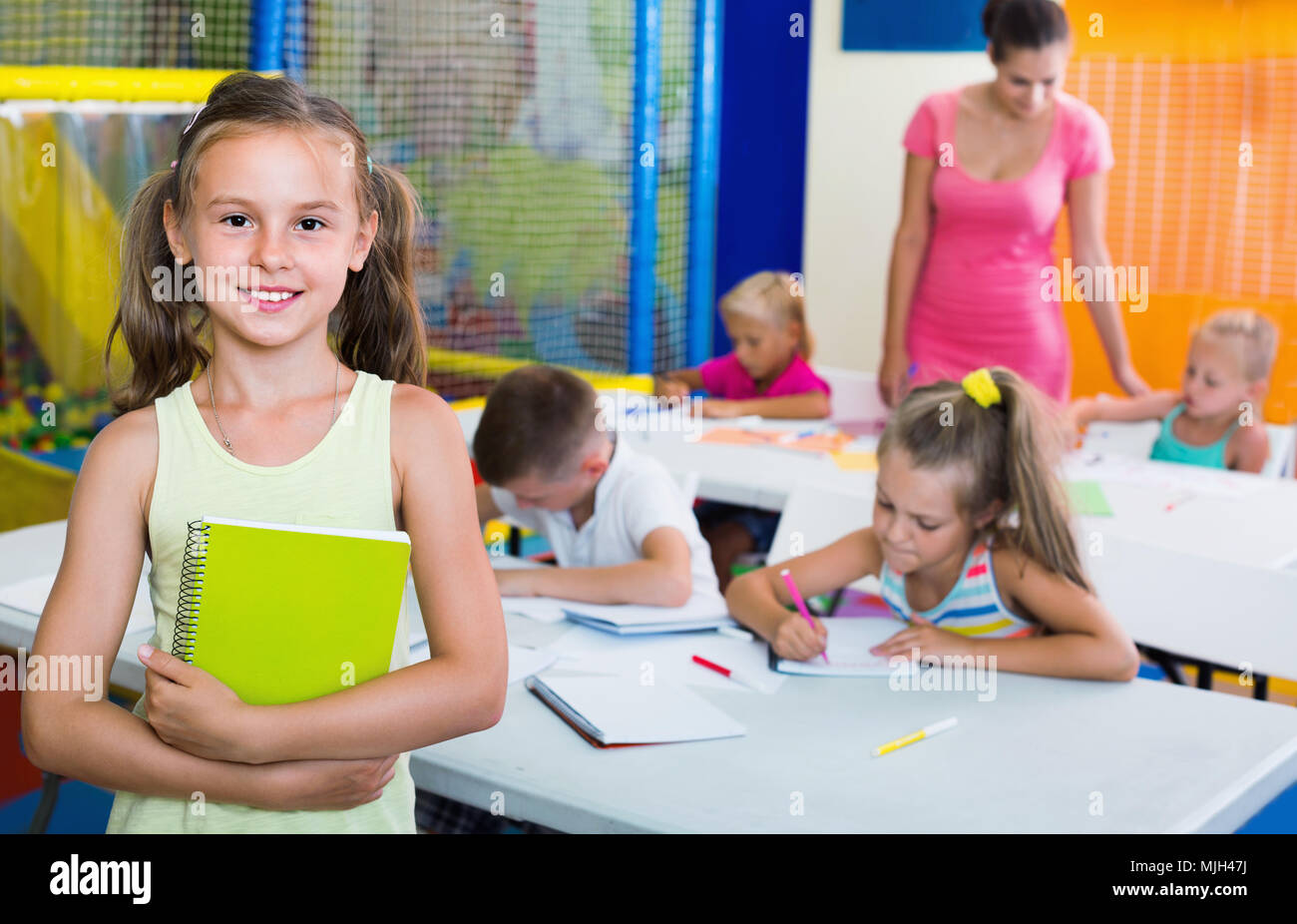 Portrait of smiling diligent pupil girl studying in school class Stock ...