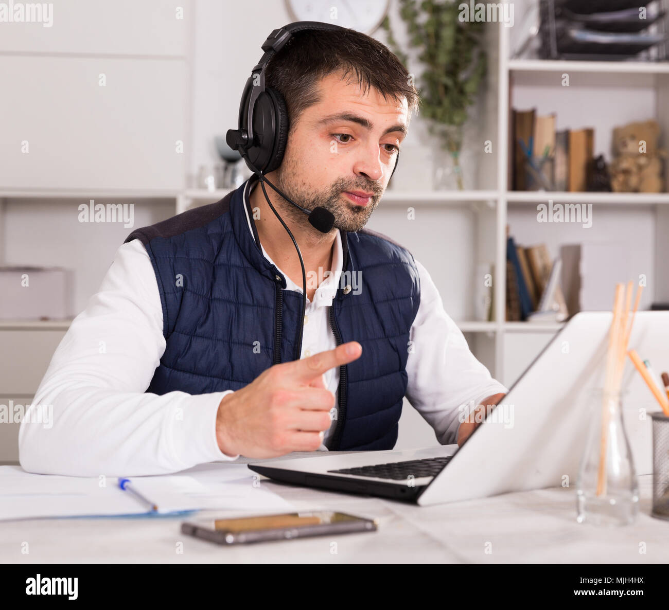Call center man operator with headset talking with client in agency ...