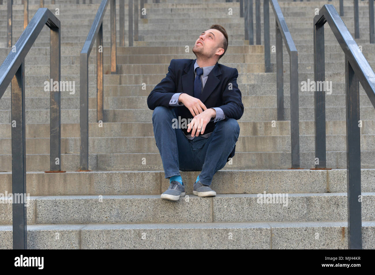 Businessman sitting on stairs looking hi-res stock photography and ...
