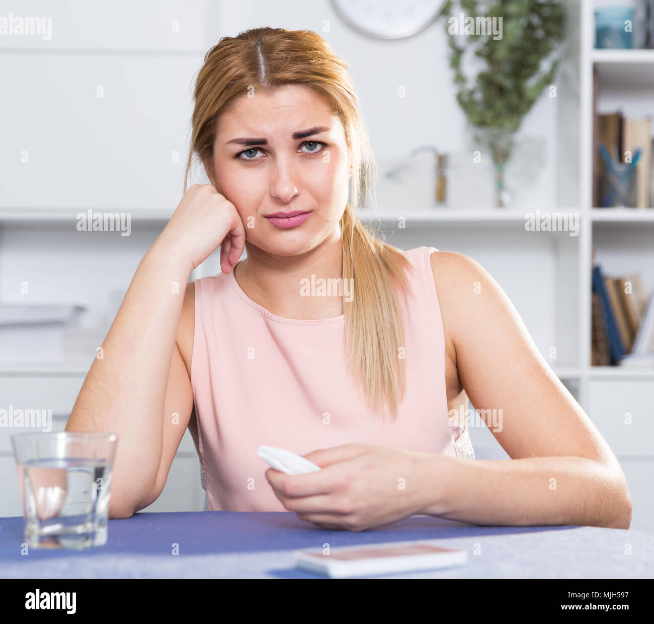 Young female is thoughtful and bored sitting alone at home Stock Photo ...