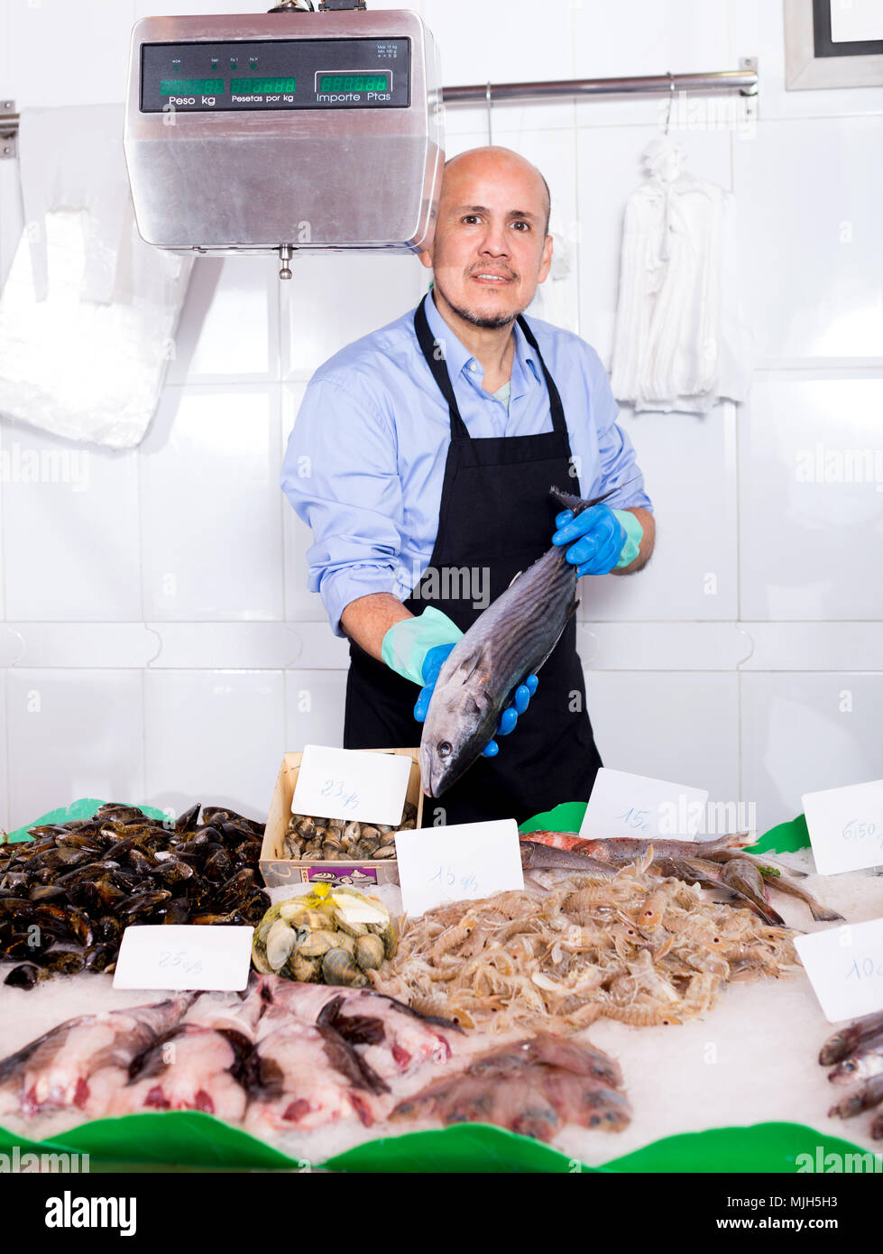 Smile man selling chilled fish and seafood in store Stock Photo - Alamy