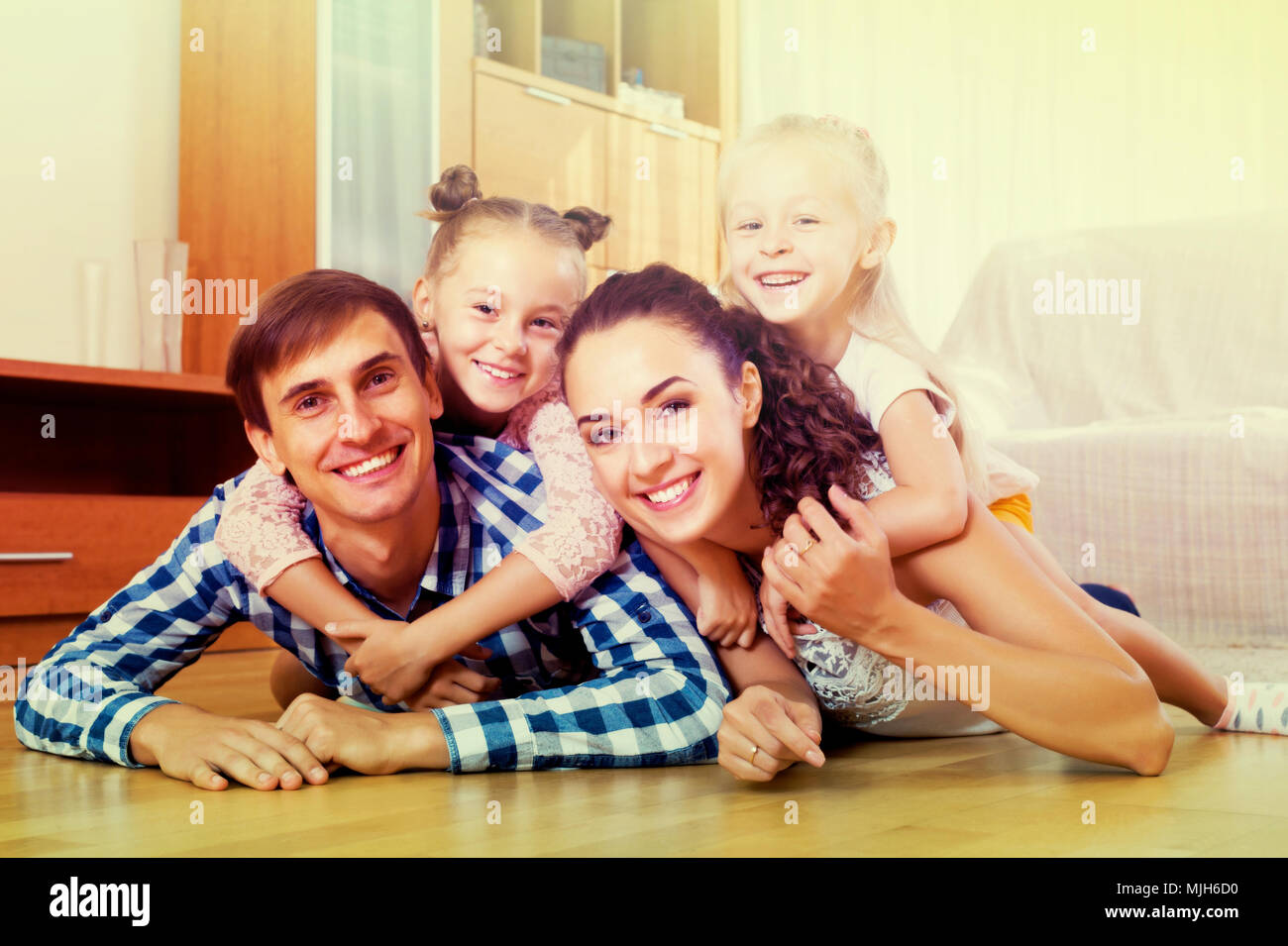 Portrait of relaxed family of four posing in domestic interior Stock ...