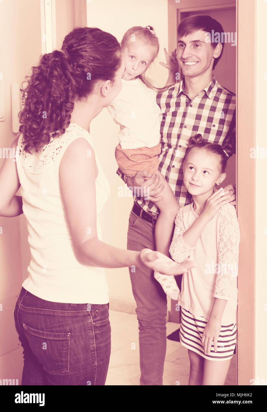 Young woman friendly welcoming smiling awaited guests at the doorway ...