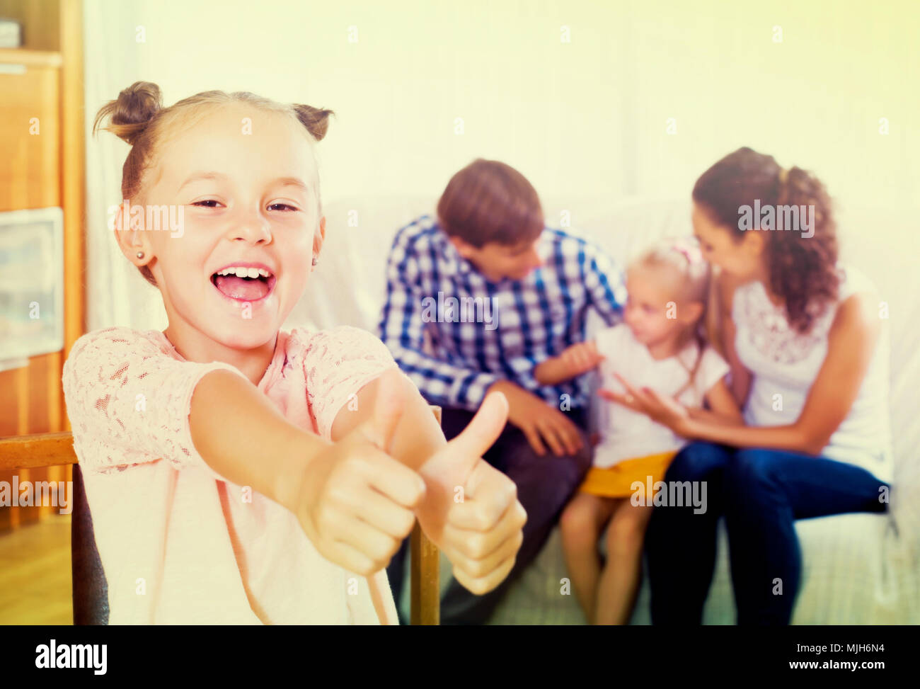 Relaxed family of four posing at home Stock Photo - Alamy