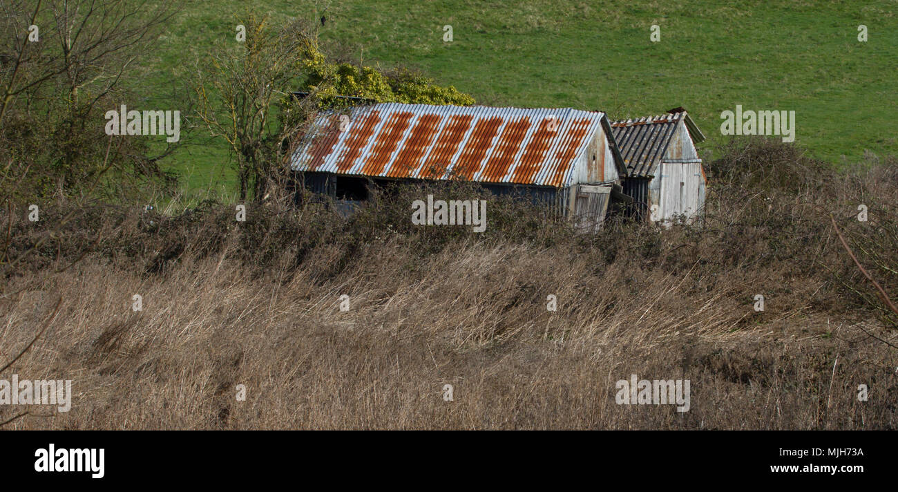 landscape photo with two old and neglected building in the country side ...