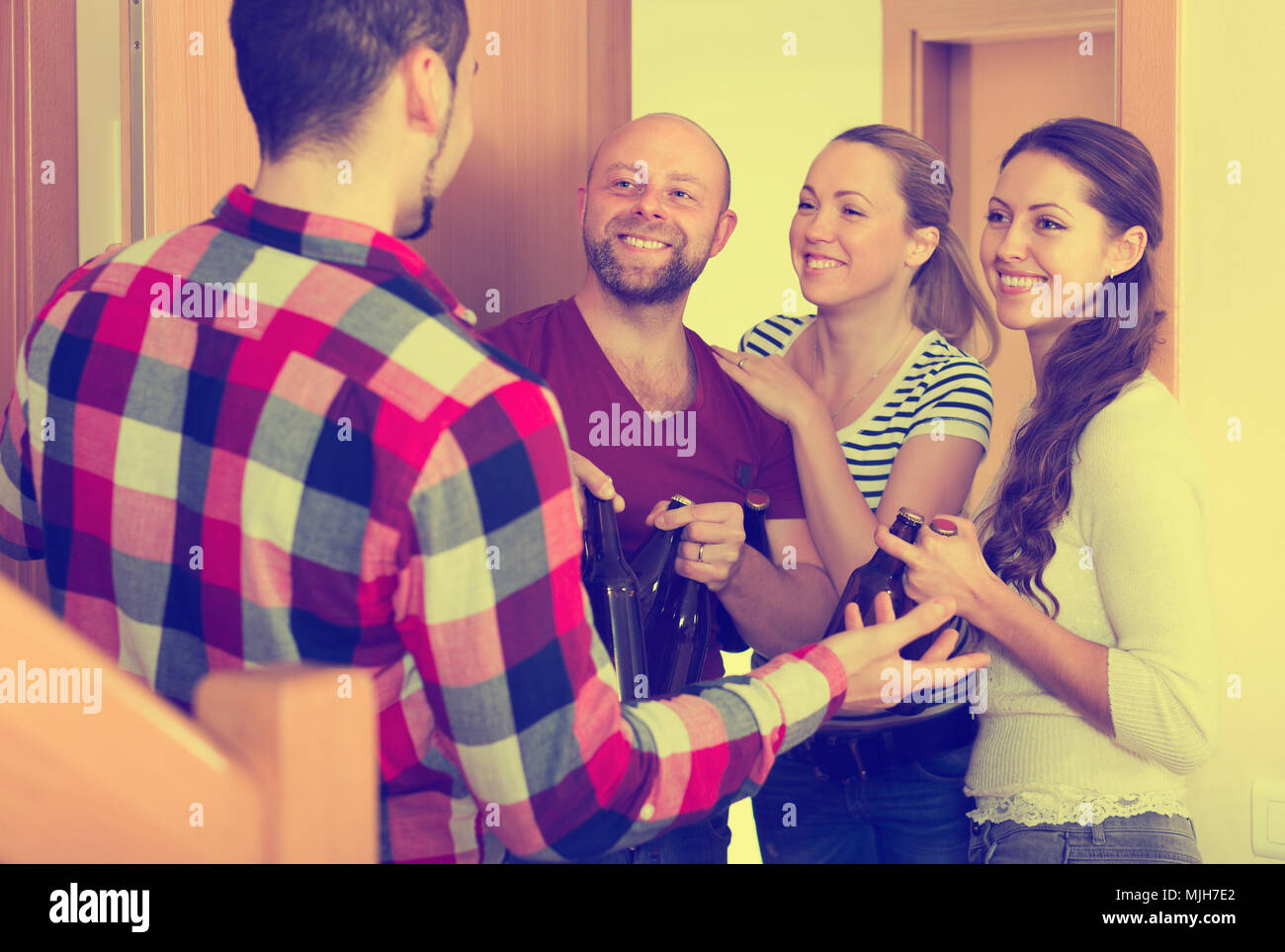 Positive adult friends gathering together at house booze party Stock ...