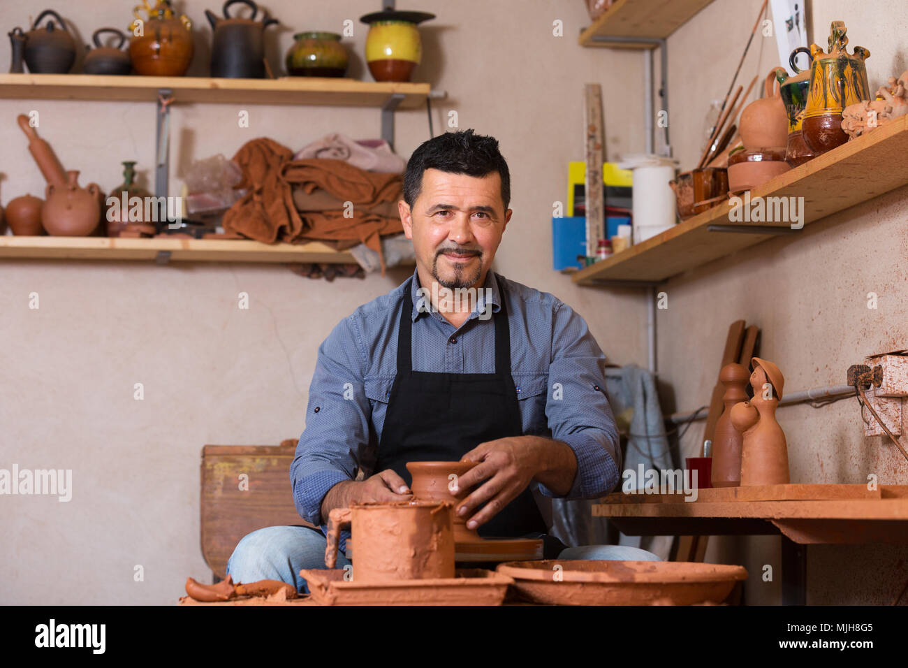Positive senior man making pot using pottery wheel in studio Stock ...