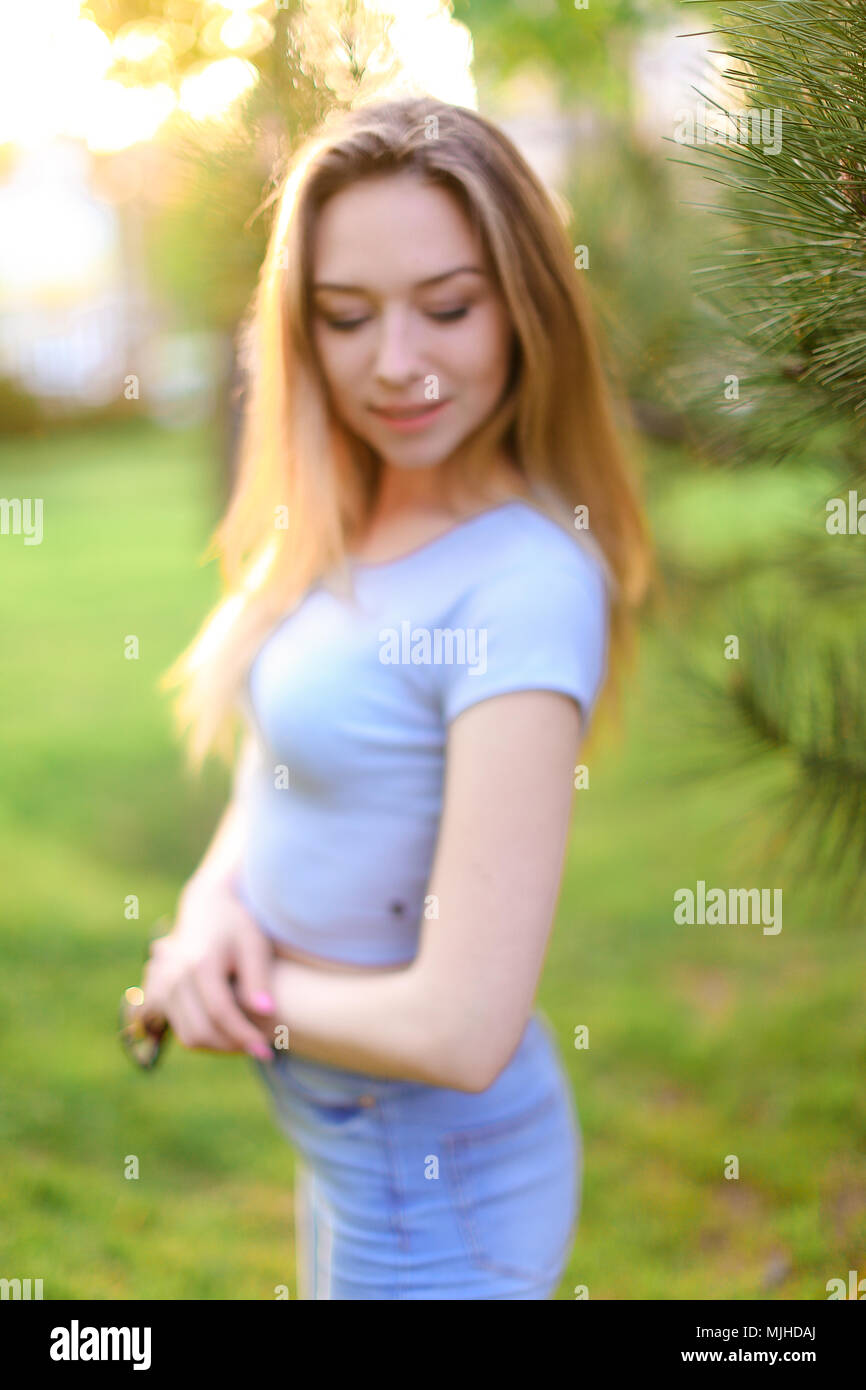 Dreaming female photo model near cedar wood in green grass background ...