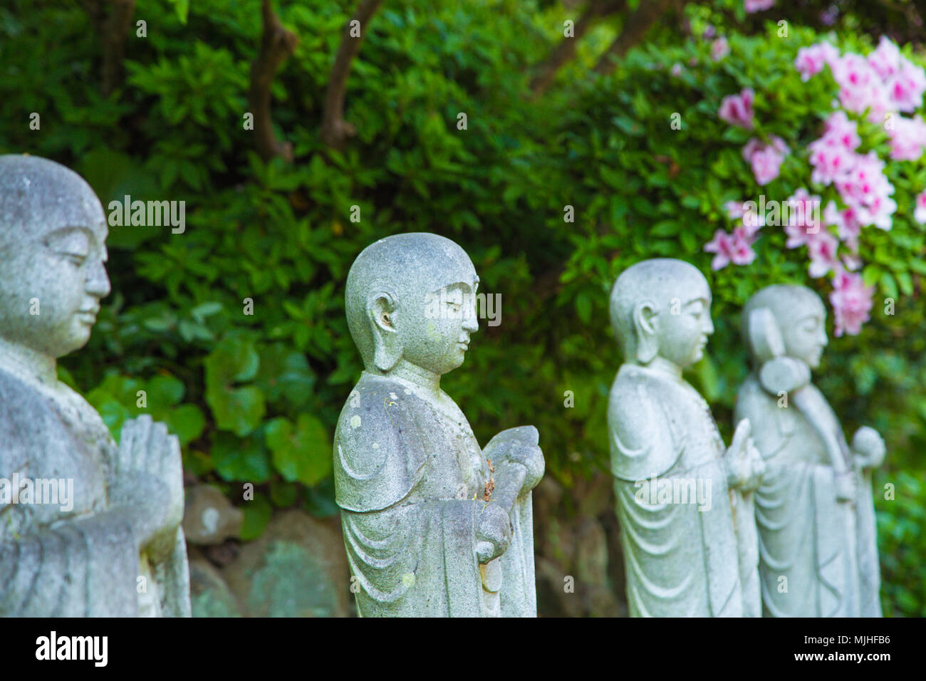Row of statues in garden surrounded by foliage Stock Photo - Alamy
