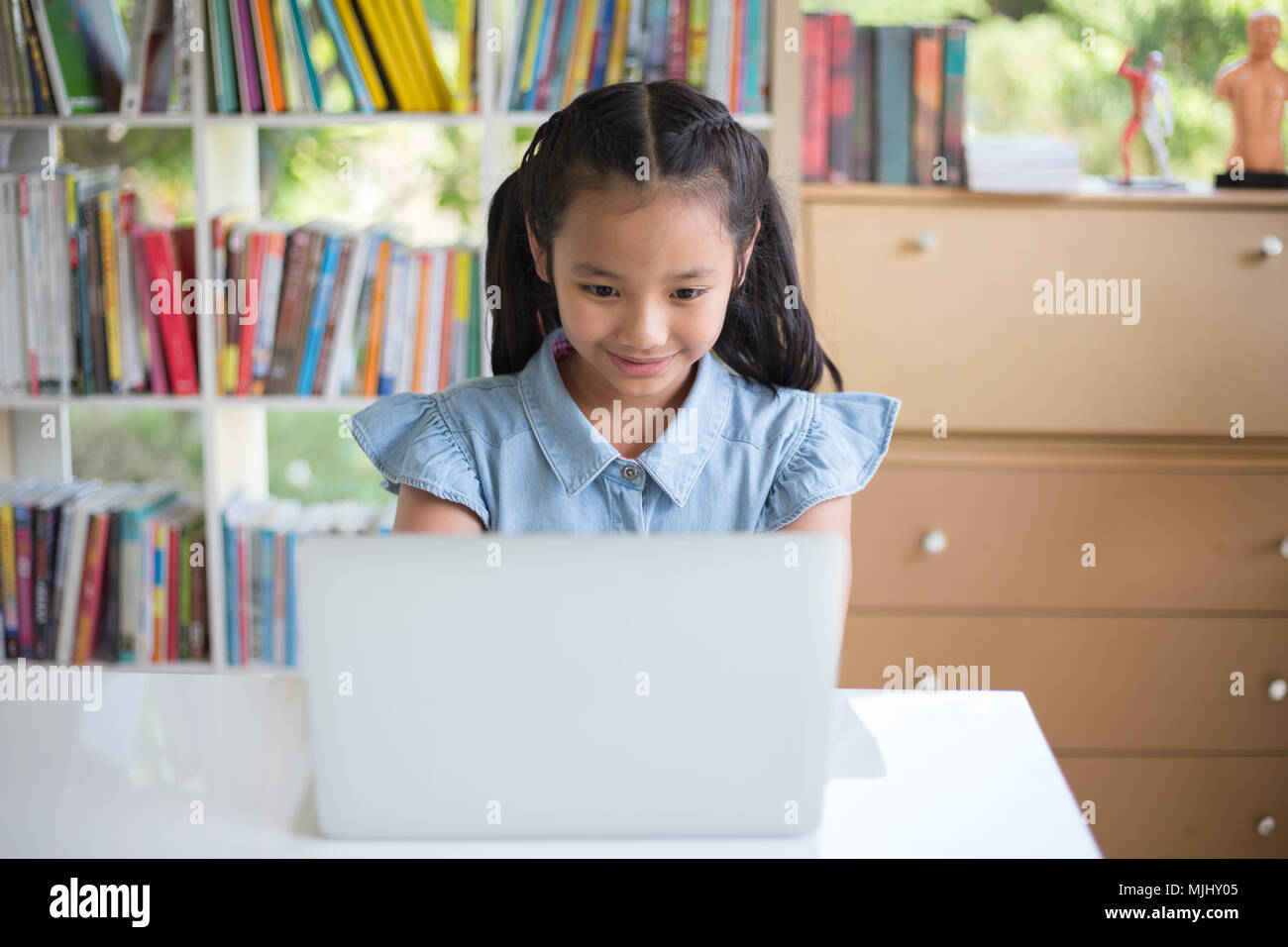 Young girl using computer at elementary school. Happy female child ...