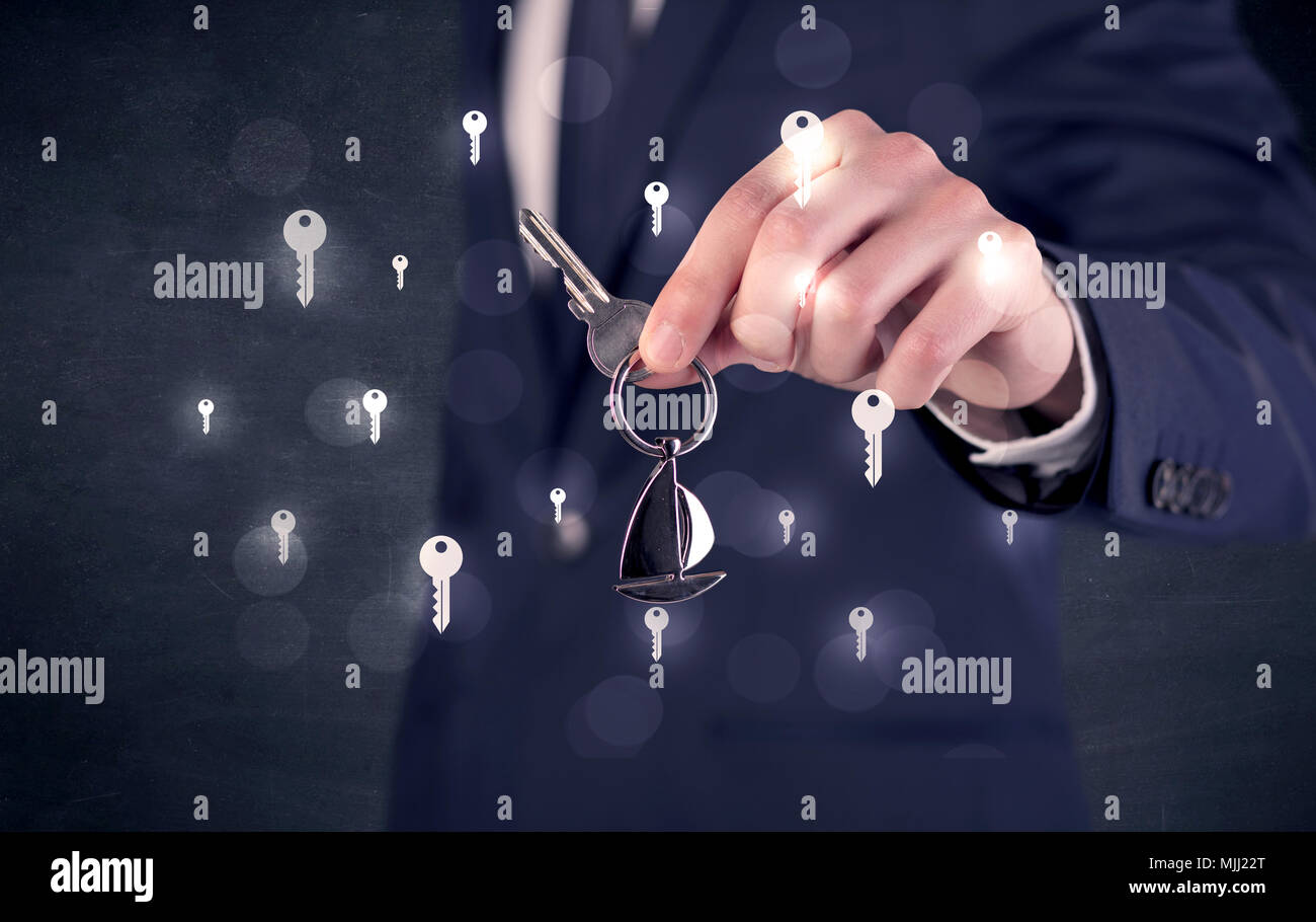 Businessman in suit holding keys with keys graphics around and dark ...