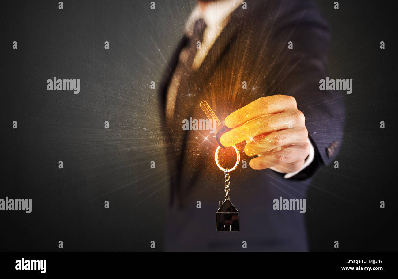 Formal man hand over shiny keys with dark background Stock Photo - Alamy