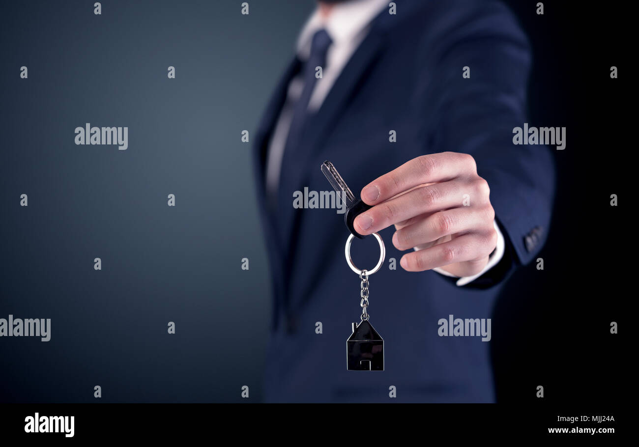 Young businessman hand over keys with empty dark background Stock Photo ...