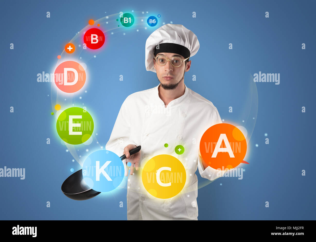 Handsome cook with kitchen instruments and vitamin concept Stock Photo ...