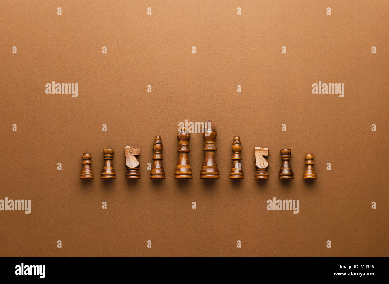 Wooden chess figurines organized in a row over brown background Stock ...