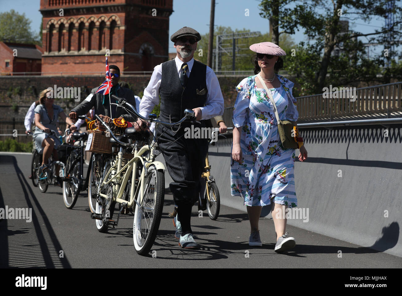 Tweed clad cyclists cross Somers Town Bridge spanning Regent's Canal ...