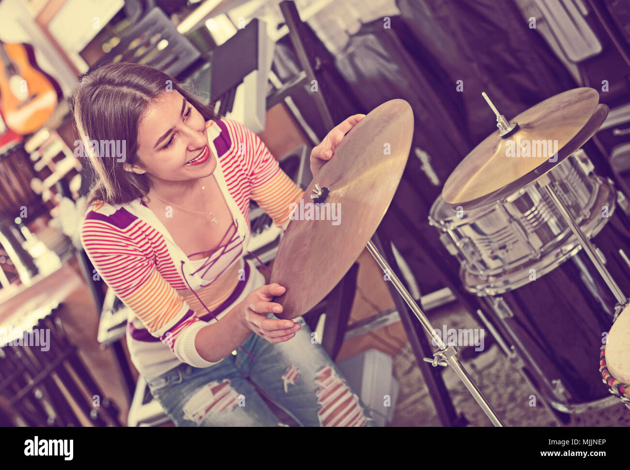 Happy teenage girl shopping drum kit in music instruments studio Stock ...
