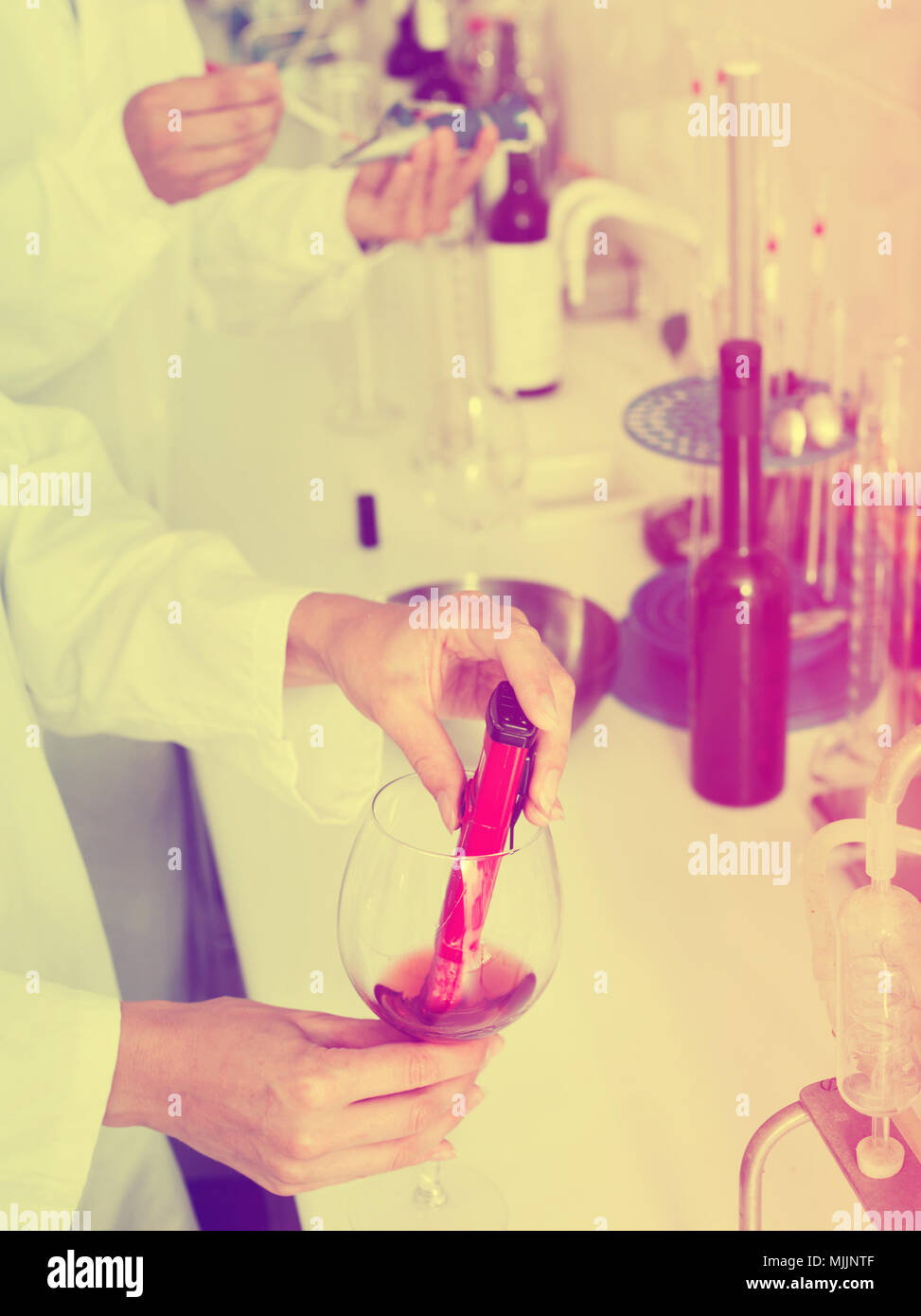 View on hands working in chemical laboratory checking wine qualities ...