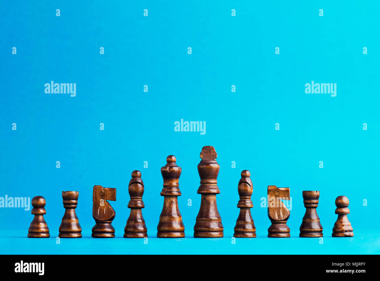 Wooden chess figurines organized in a row over blue background Stock ...