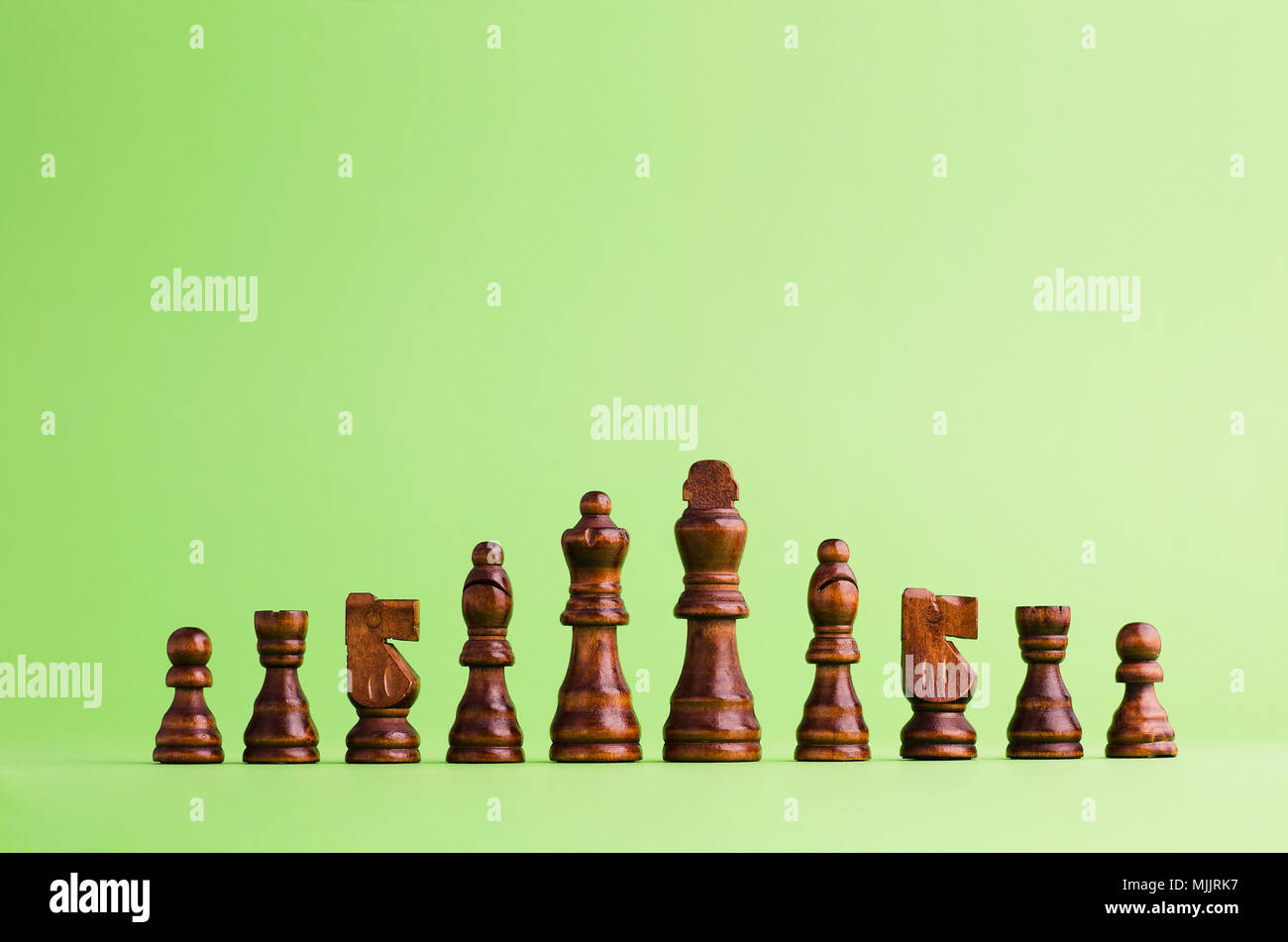 Wooden chess figurines organized in a row over green background Stock ...