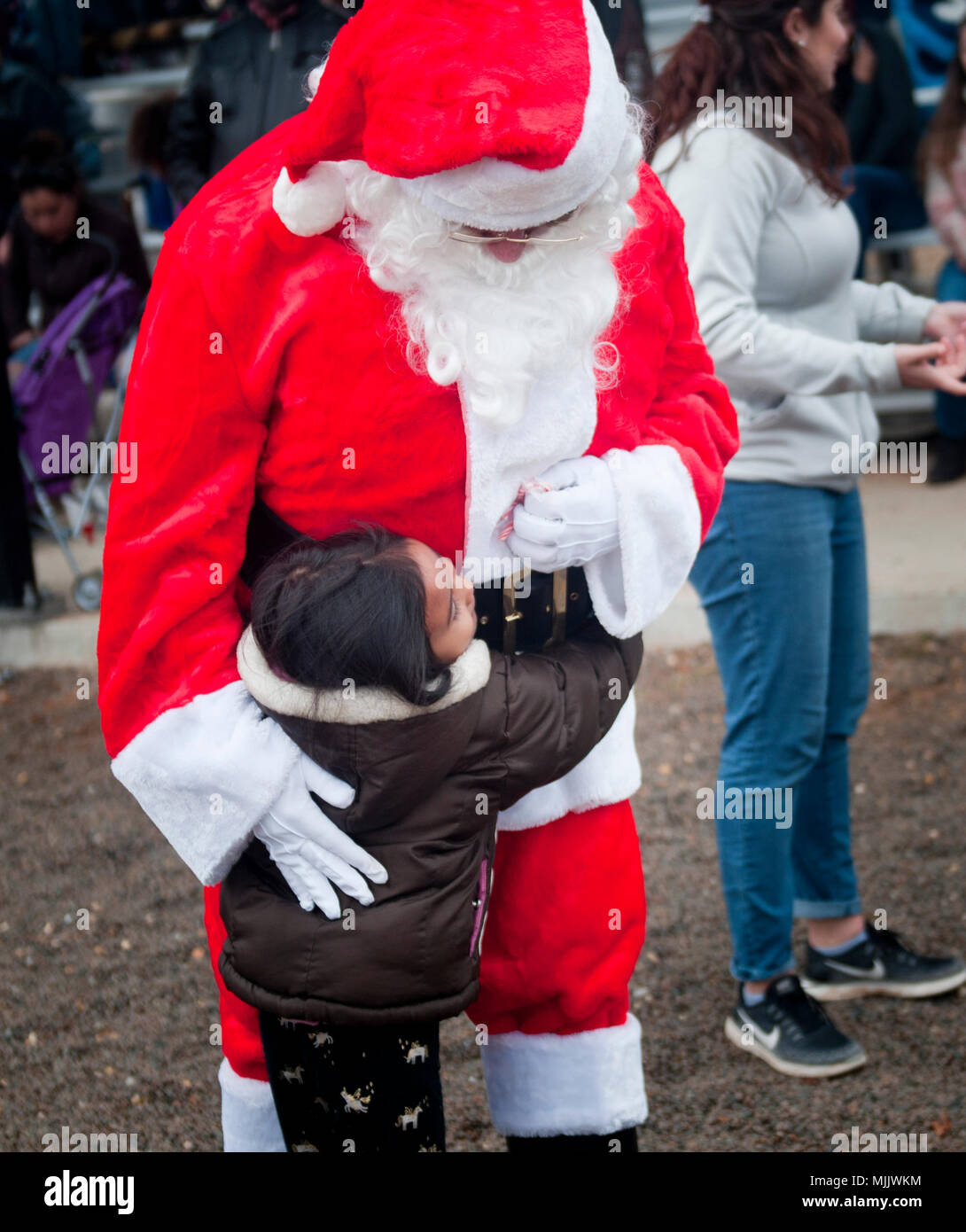 A child eagerly greets Santa Claus as he walks off the drop zone during ...