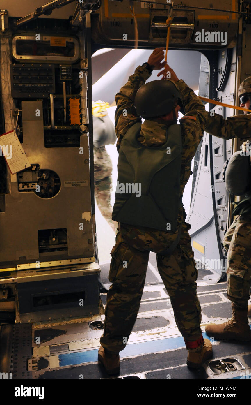 U.S. Army Staff Sgt. Bryan Llamas grabs the universal static lines as ...