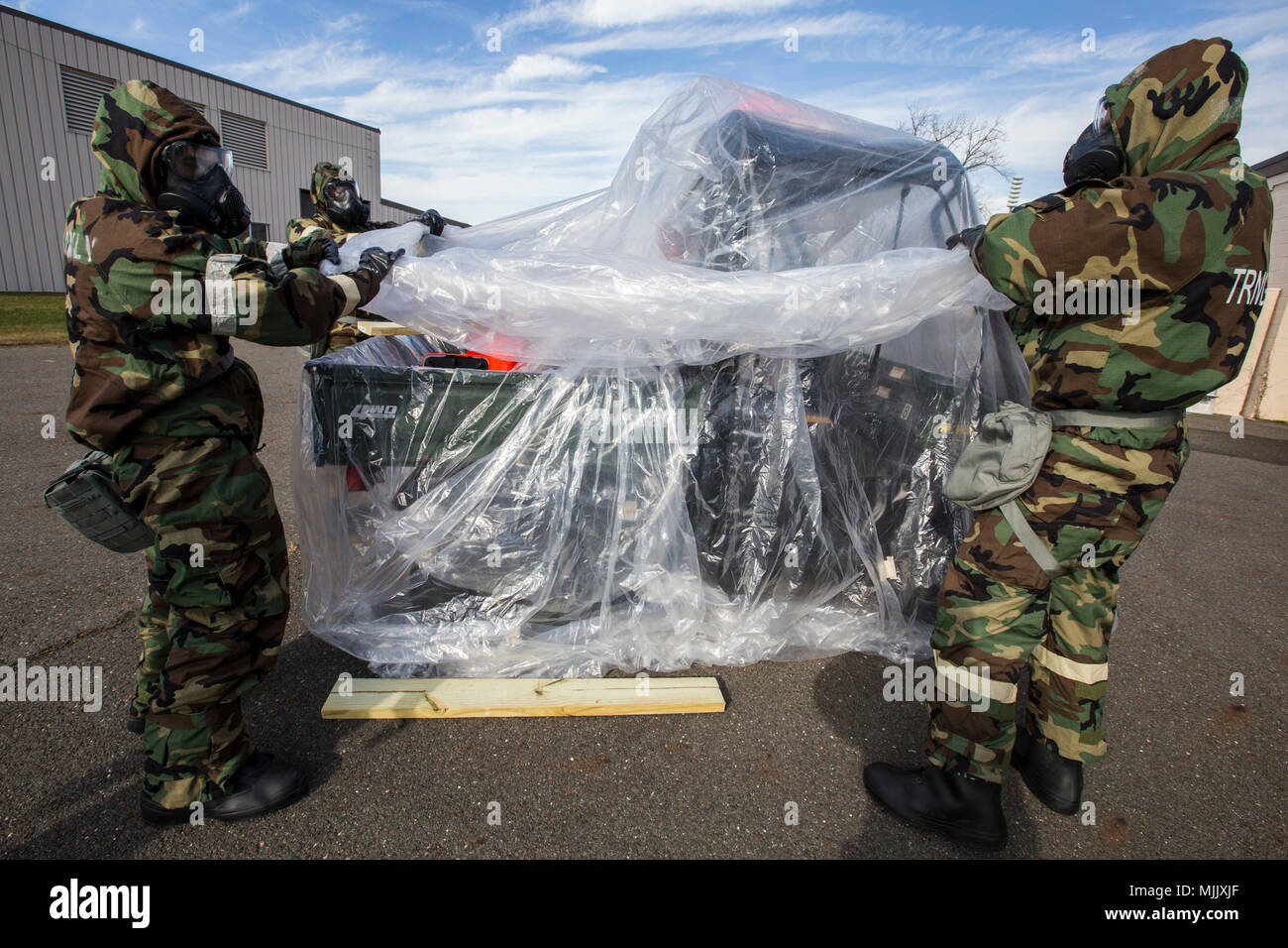 U.S. Air Force Airmen with the 514th Air Mobility Wing cover a vehicle ...