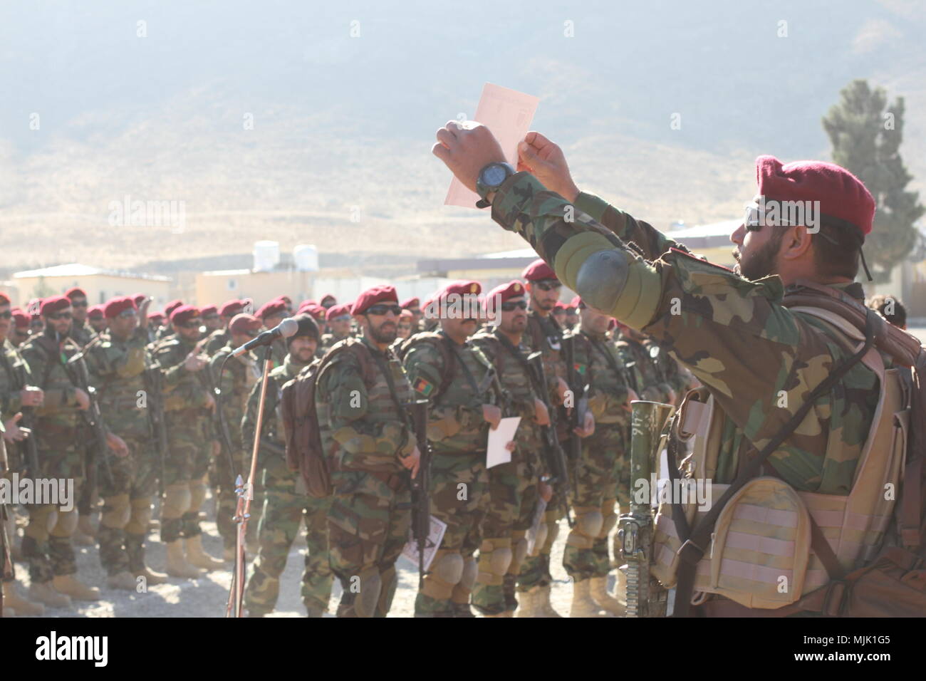 An Afghan Commando presents his course certificate to his fellow ...