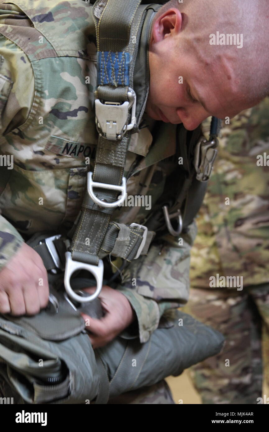U.S Army paratroopers don their parachutes before Jumpmaster Personal ...