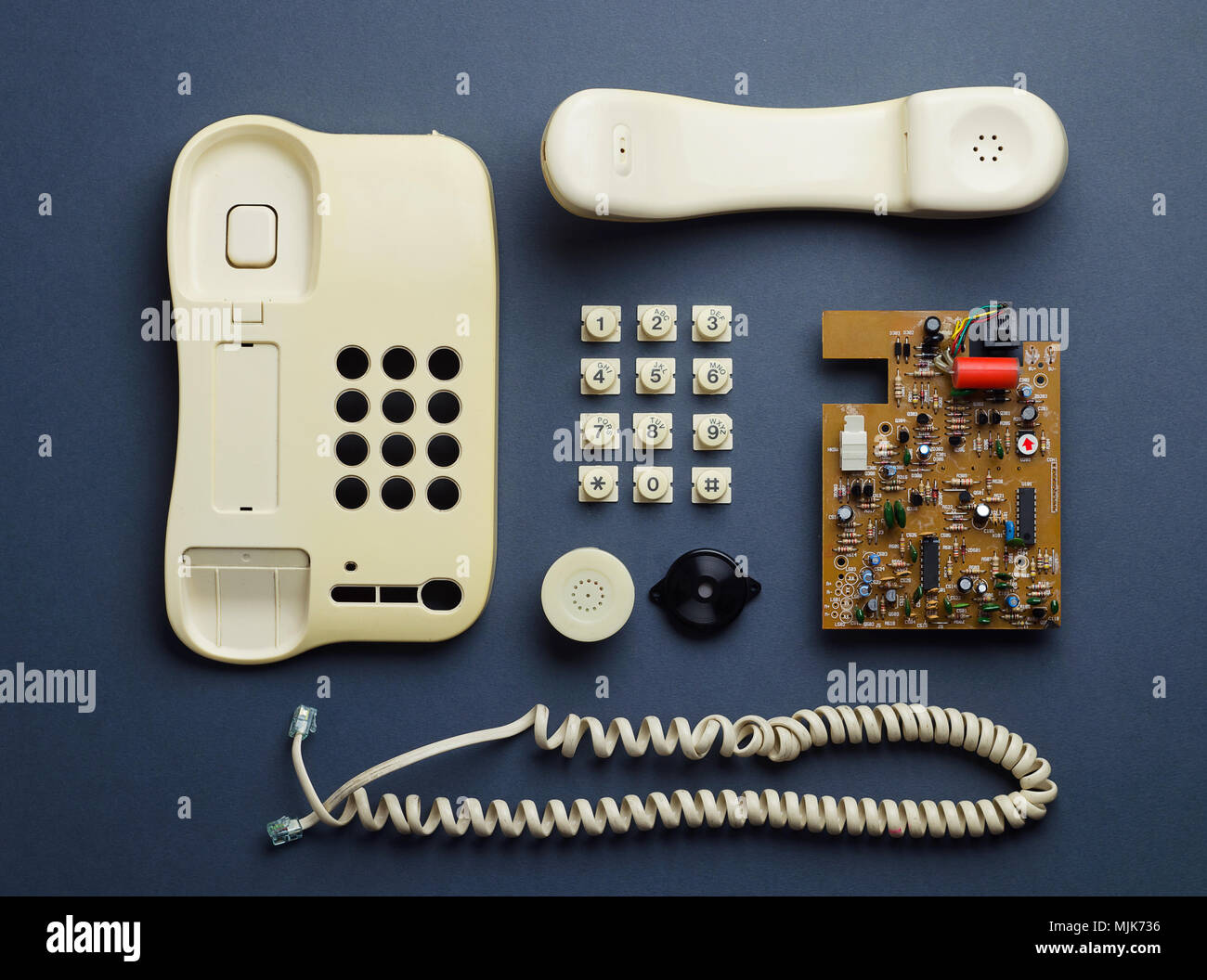 Parts of vintage home telephone well organized over dark blue ...