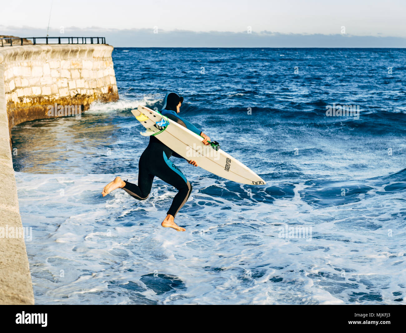 Young surfer jumping the air seashore hi-res stock photography and ...