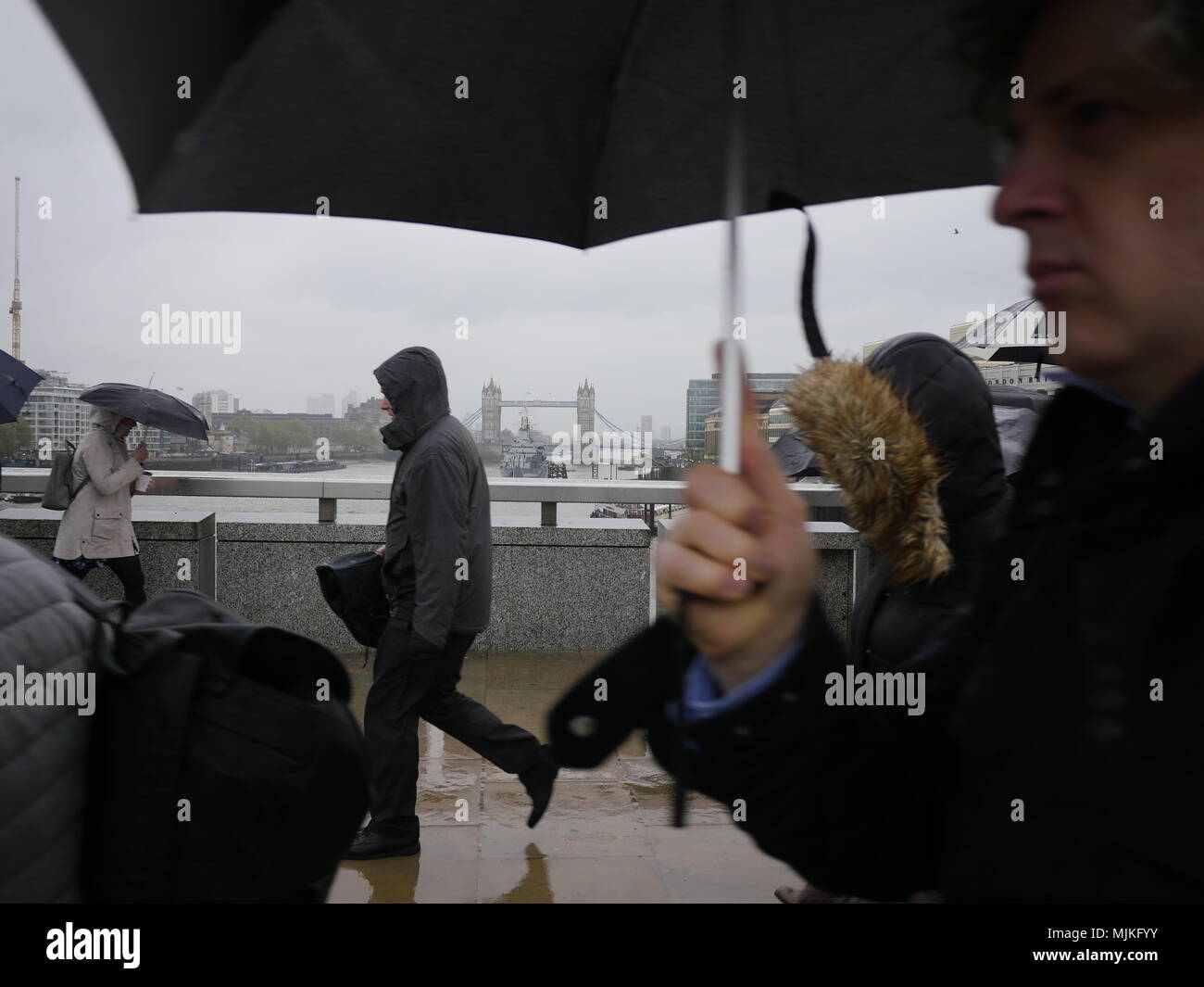Commuters on London bridge during morning rain storm Stock Photo - Alamy