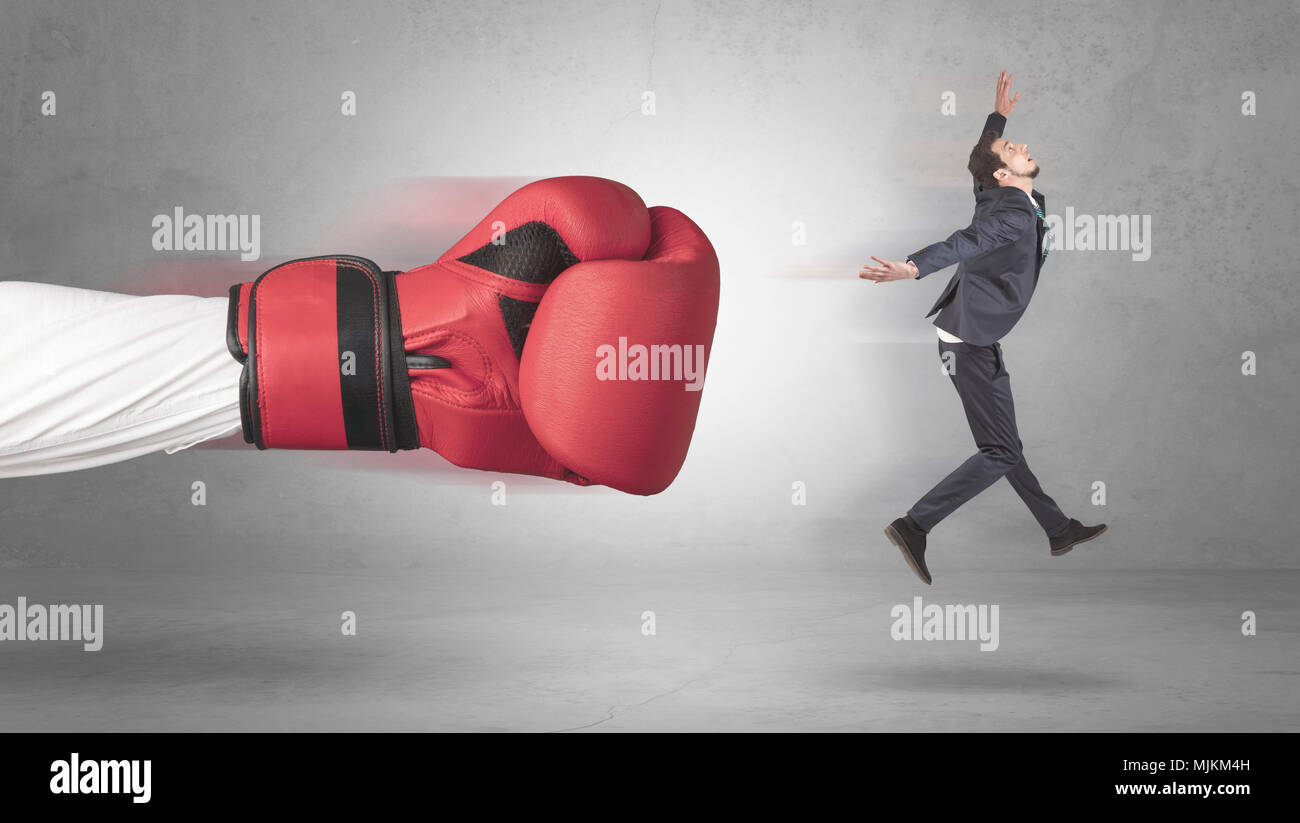 Businessman gets a hit from a giant hand with boxing gloves Stock Photo ...
