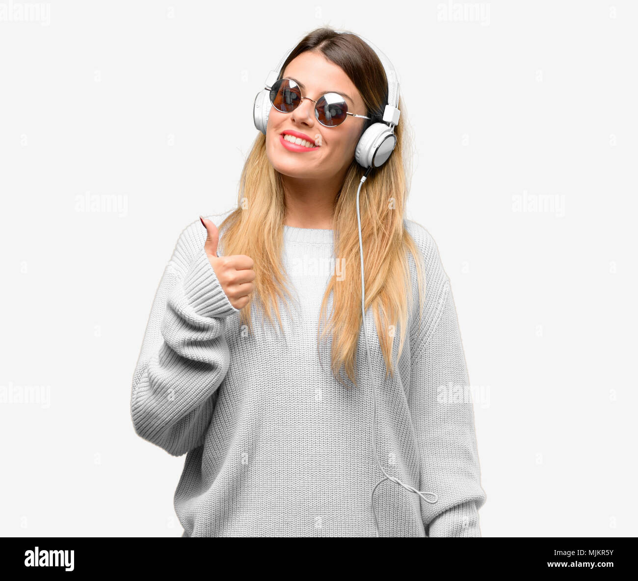 Young woman listen to music with headphone smiling broadly showing ...