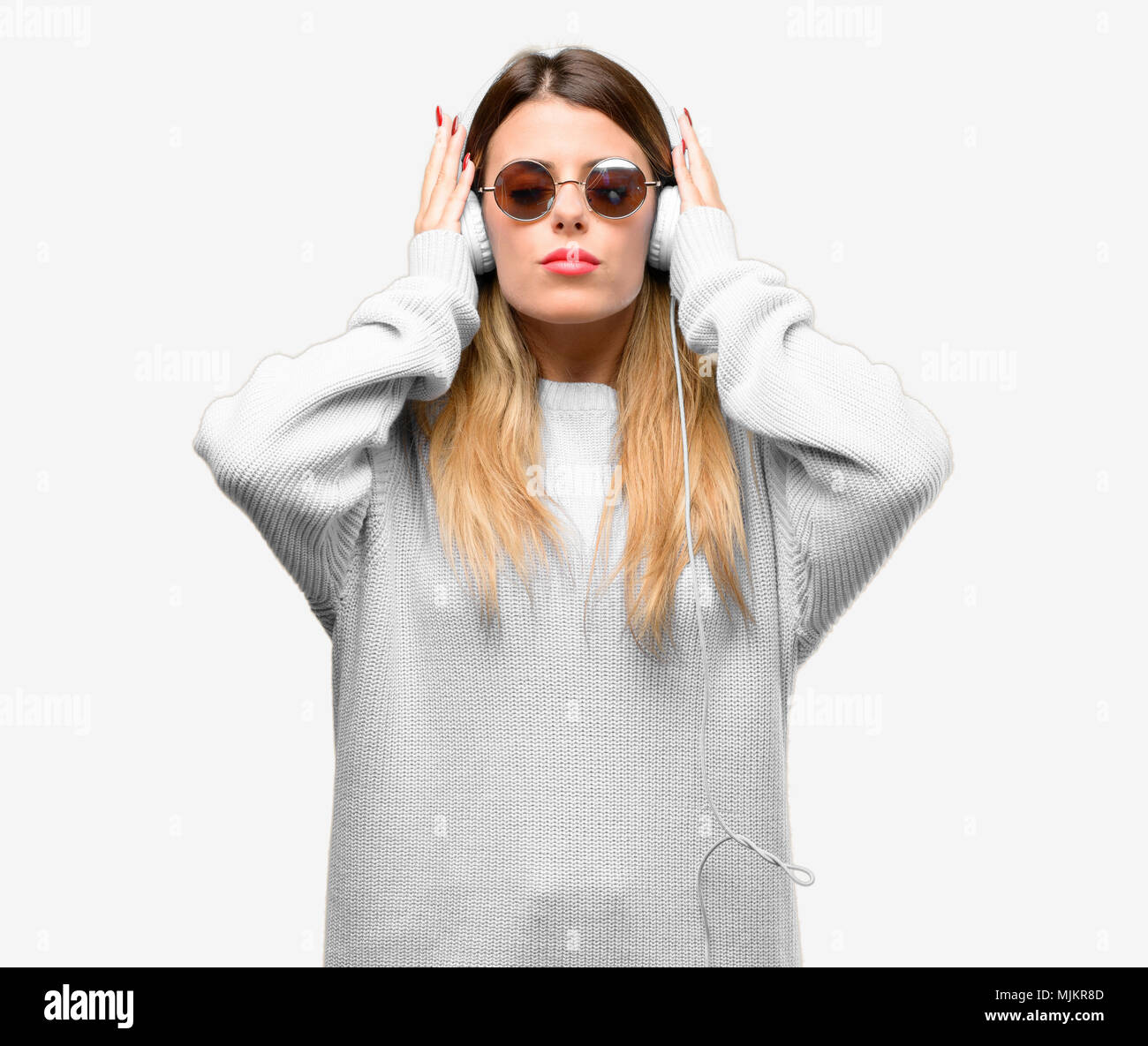 Young woman listen to music with headphone covering ears ignoring ...