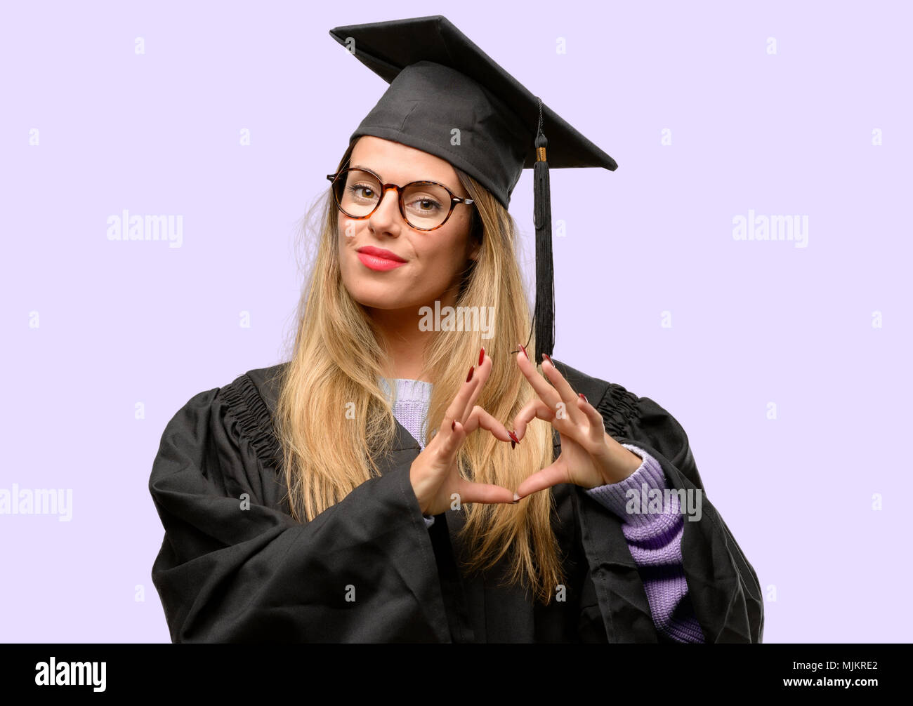 Young woman university graduate student happy showing love with hands ...