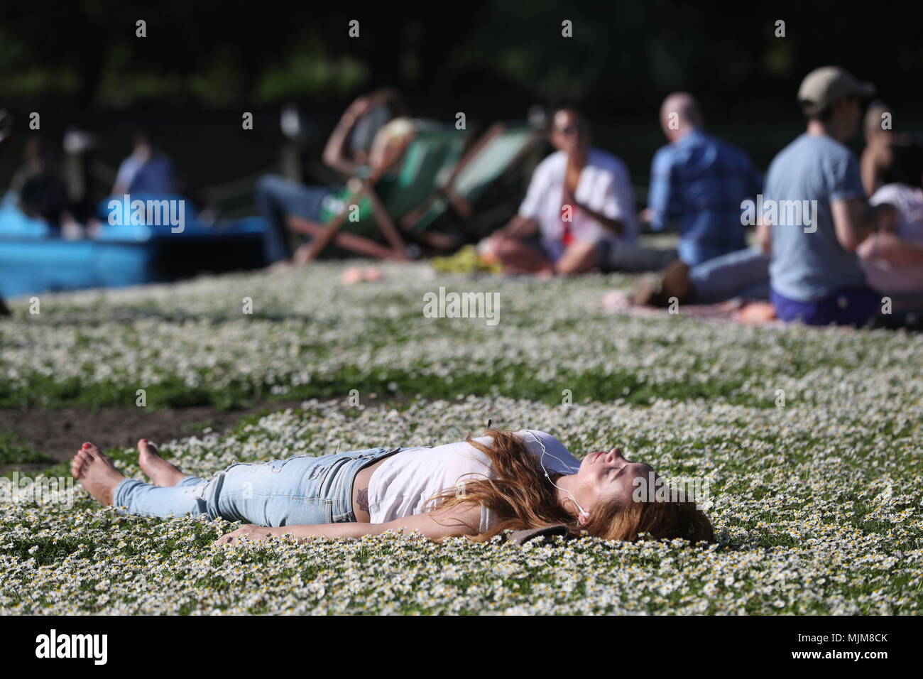 People enjoy the sun in Regent's Park London, as sun worshippers are ...