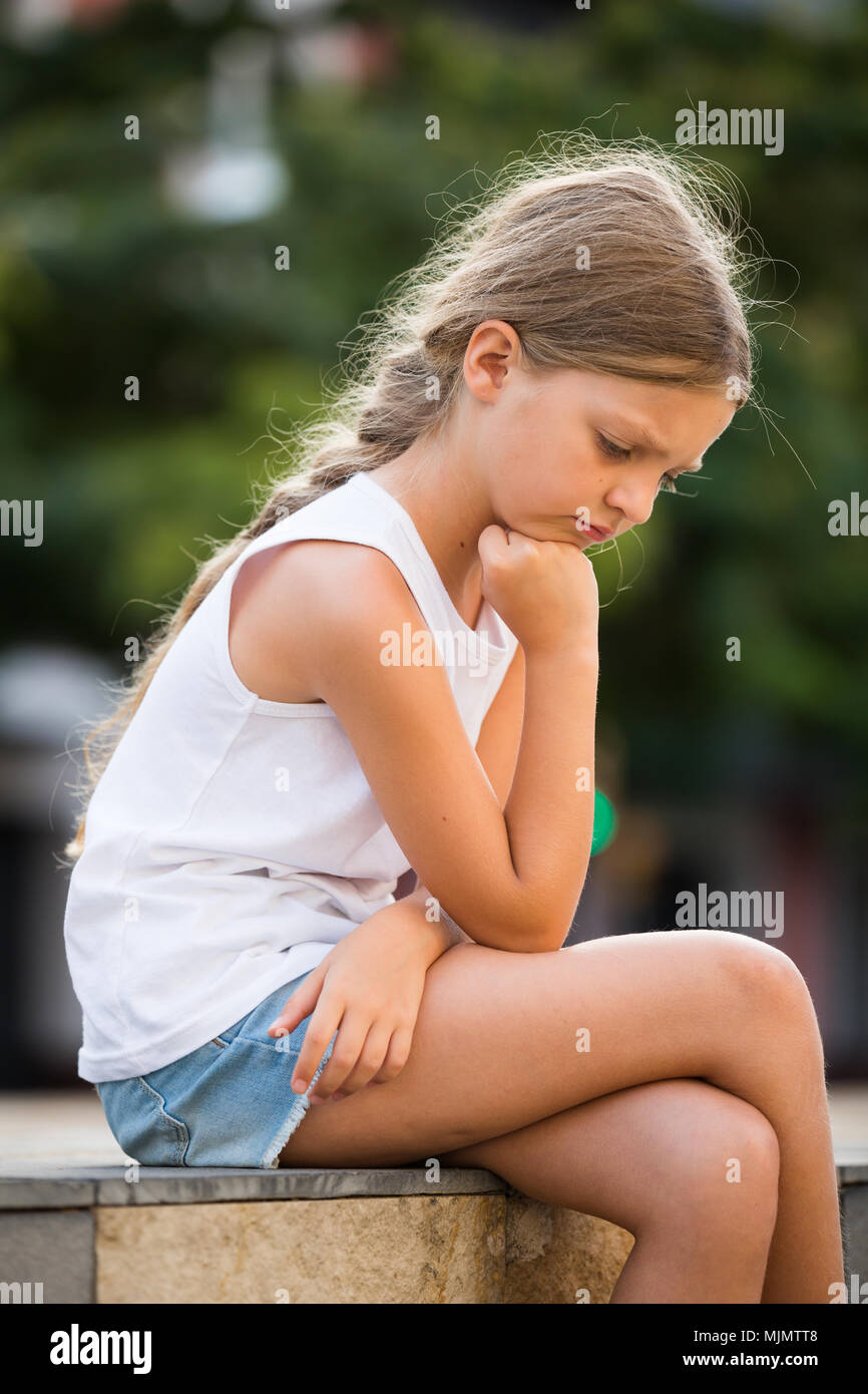 Lonely girl in elementary school age crying and feeling confused ...