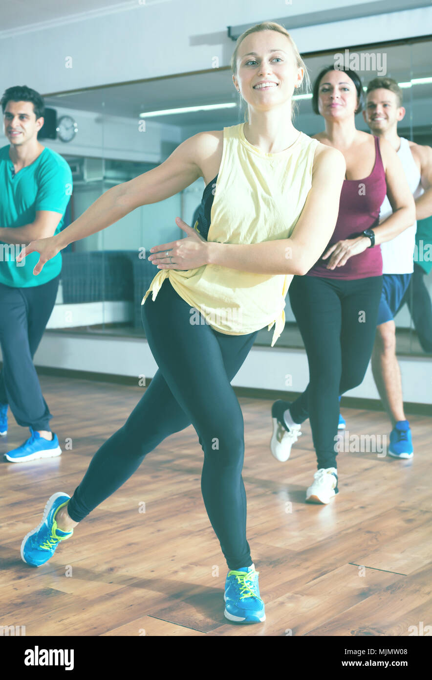 Happy people learning zumba steps in dance hall Stock Photo - Alamy