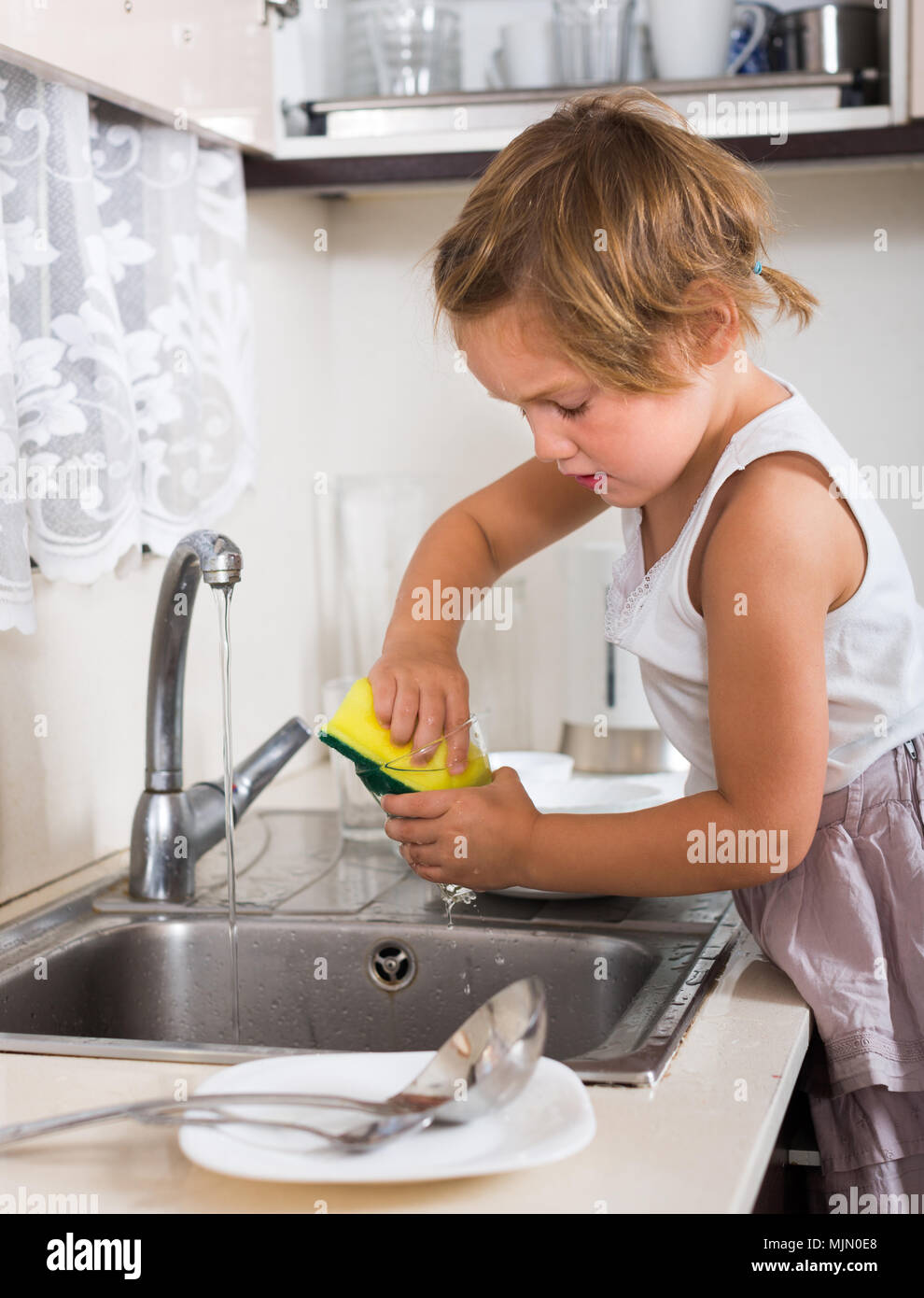 Happy cute child washing dishes at domestic kitchen Stock Photo - Alamy