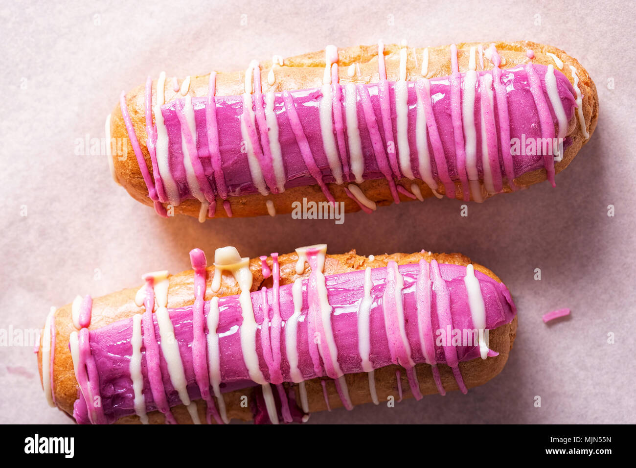 Blackcurrant eclairs. Choux pastries with blackcurrant creme patisserie, topped with ...