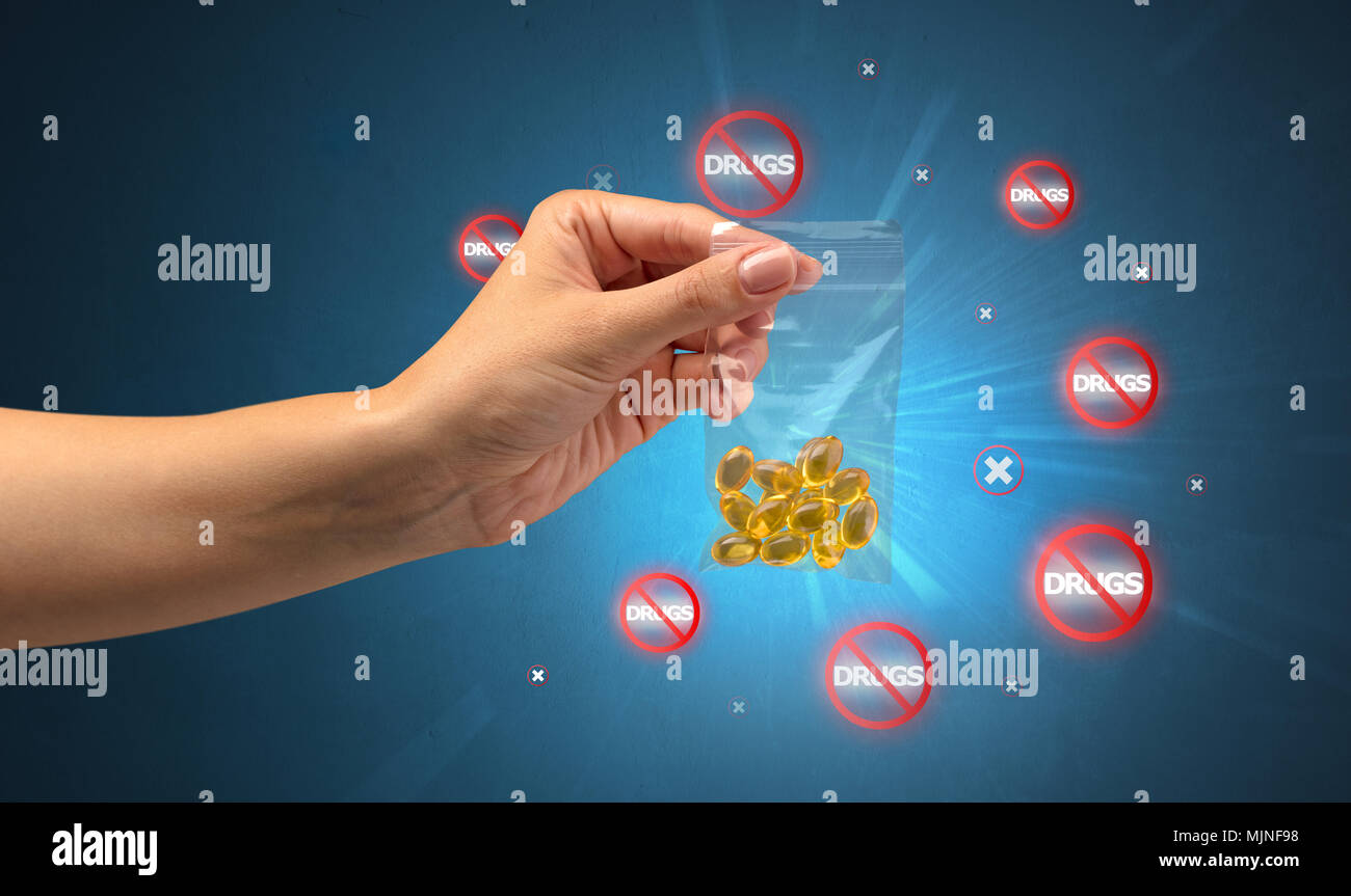 Hand giving pills with anti-drug concept and not allowed signs around ...
