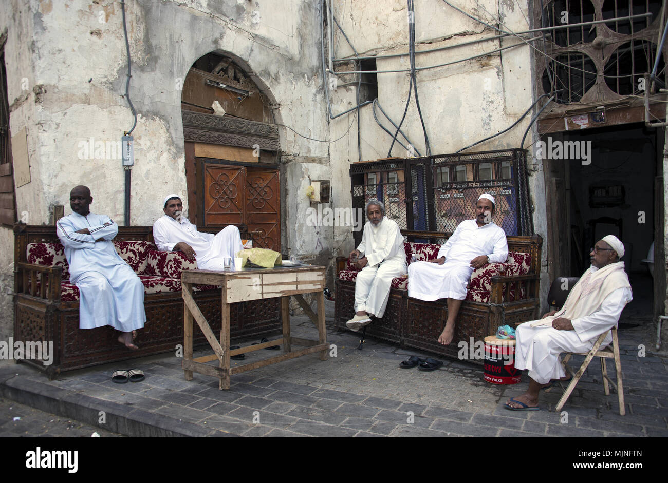 group of men gathered on a street corner in Al Balad, the historic ...