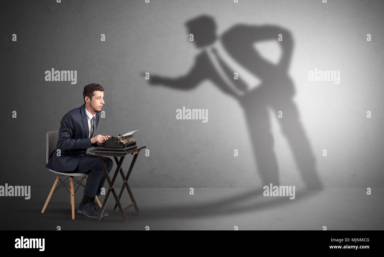 Little man working and a big shadow arguing with him Stock Photo - Alamy