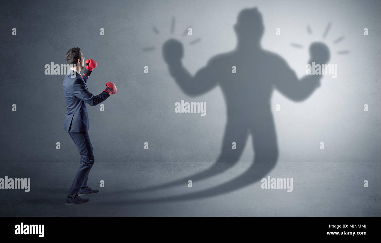 Businessman trying to fight with his unarmed shadow Stock Photo - Alamy