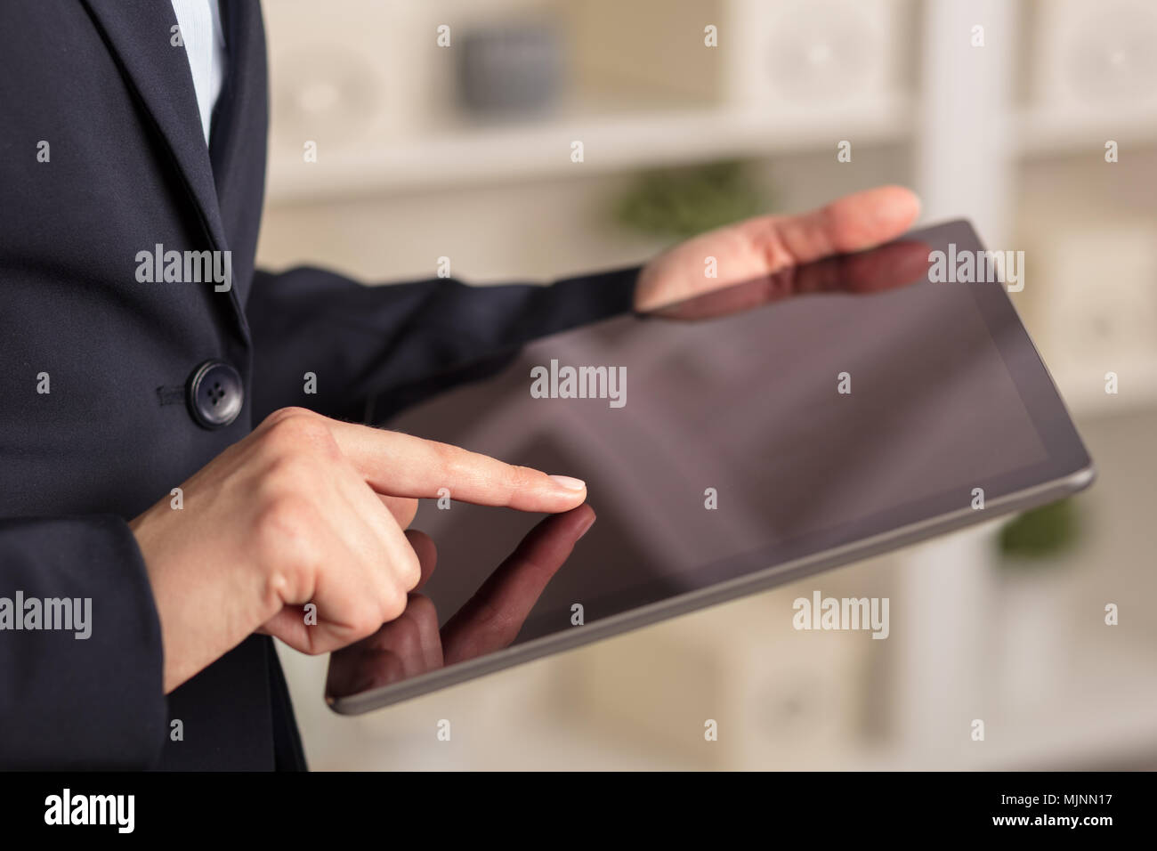 Business woman below chest using tablet in a homey environment Stock ...