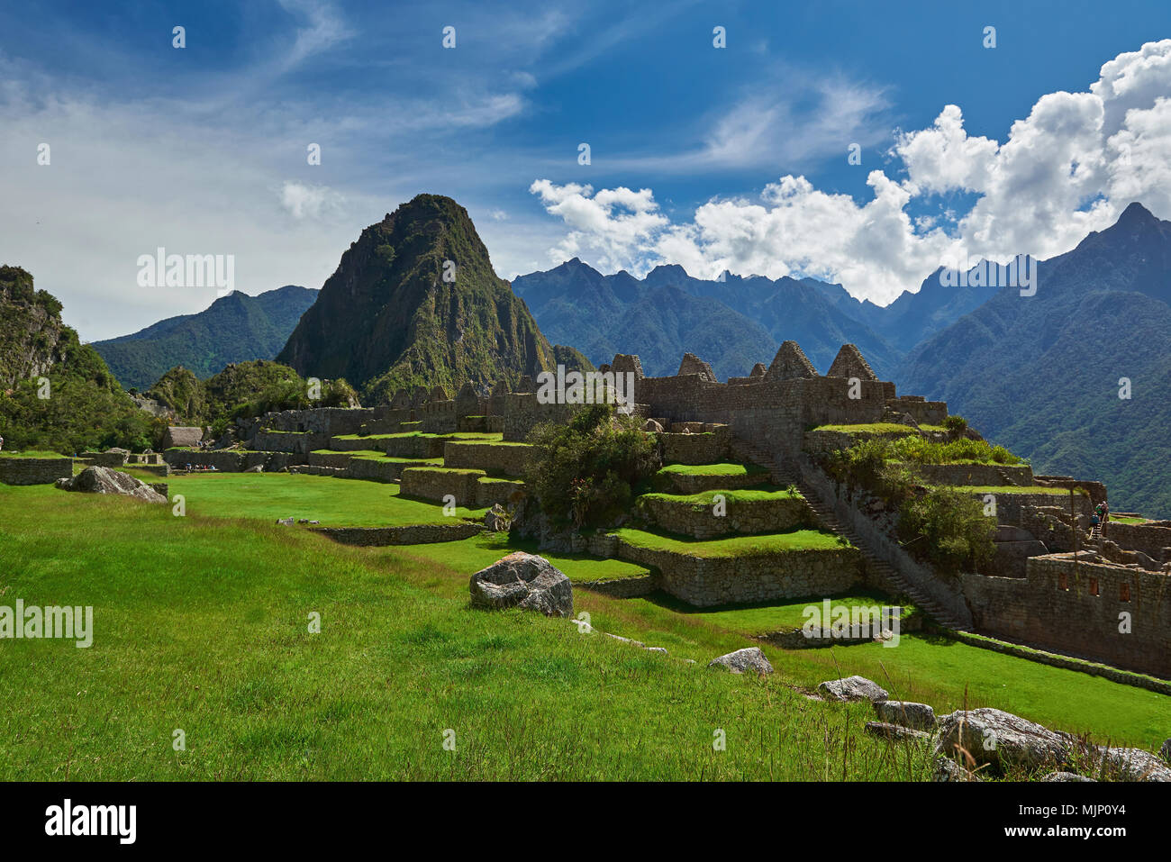 Beautiful day in Machu Picchu ancient Inca city. Green grass field in ...